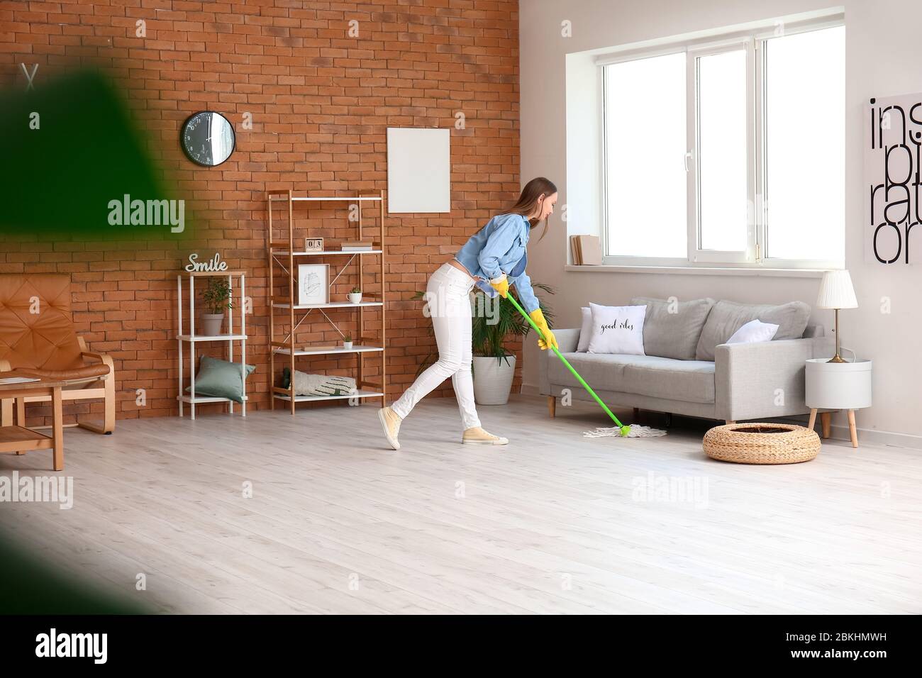 Young woman mopping floor in room Stock Photo - Alamy
