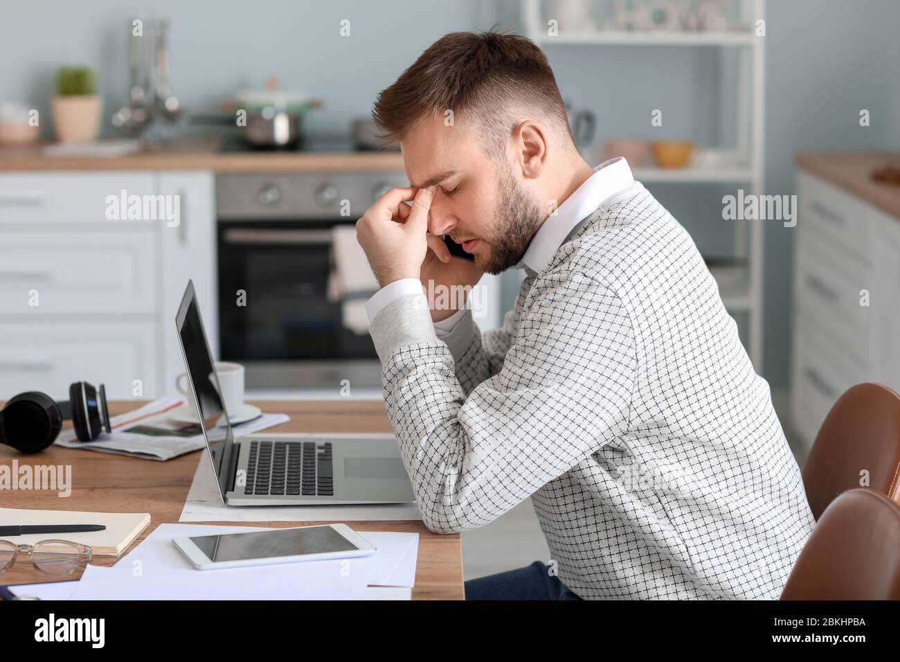 Tired young man working at home Stock Photo - Alamy