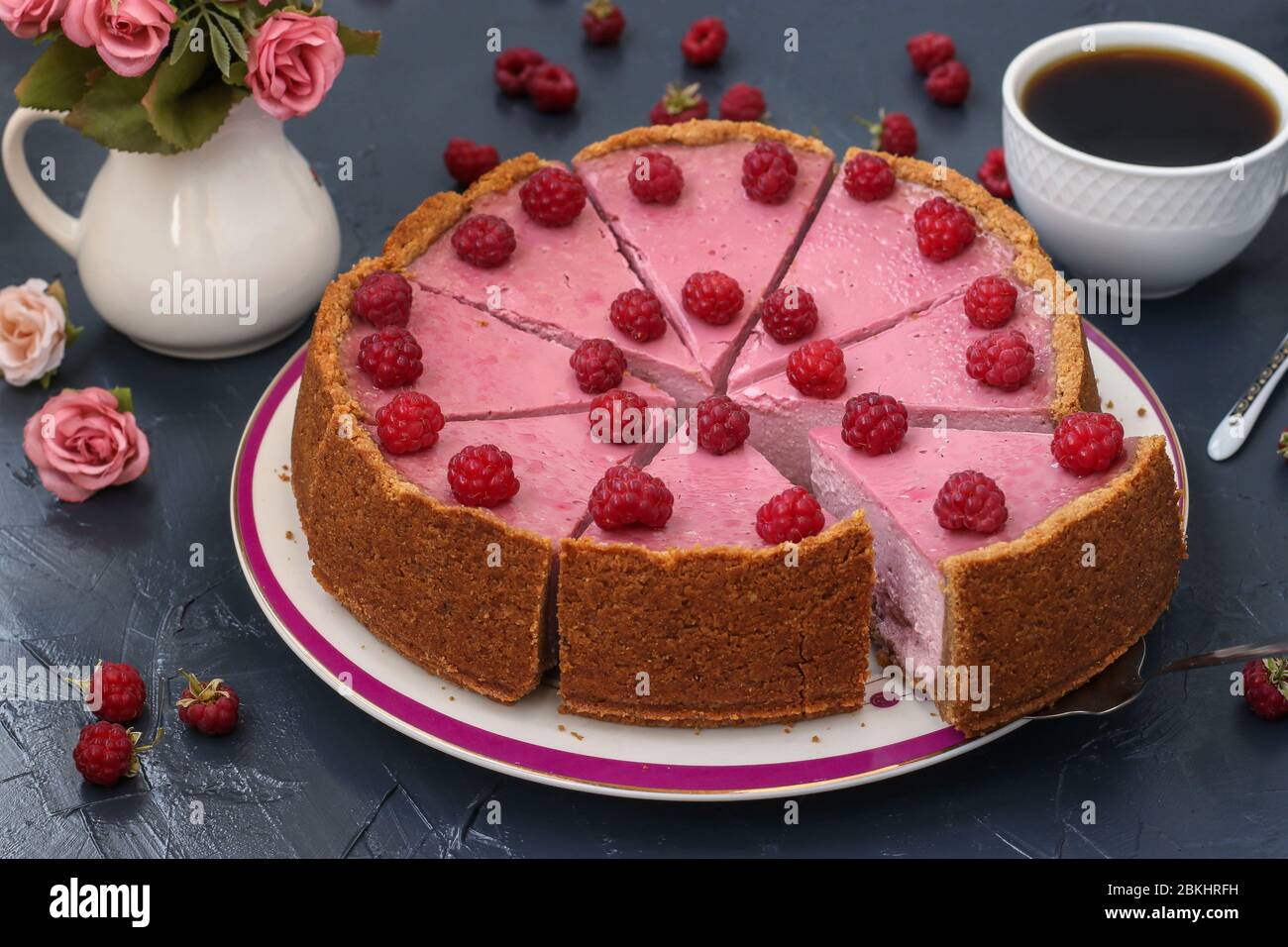 Homemade raspberry cheesecake cut in portions on a plate, located on ...