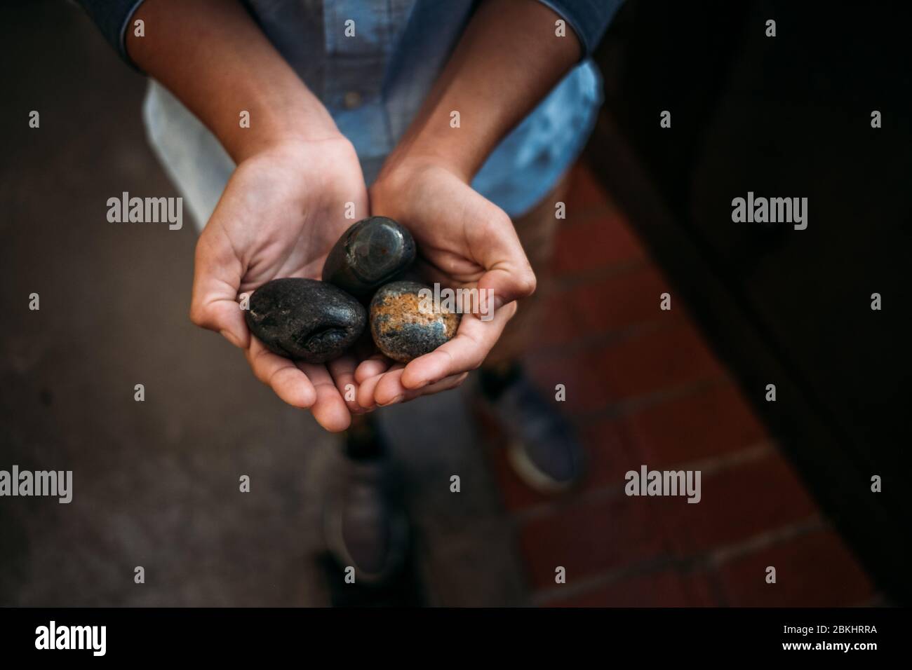 portrait of child holding rocks in their hands Stock Photo - Alamy