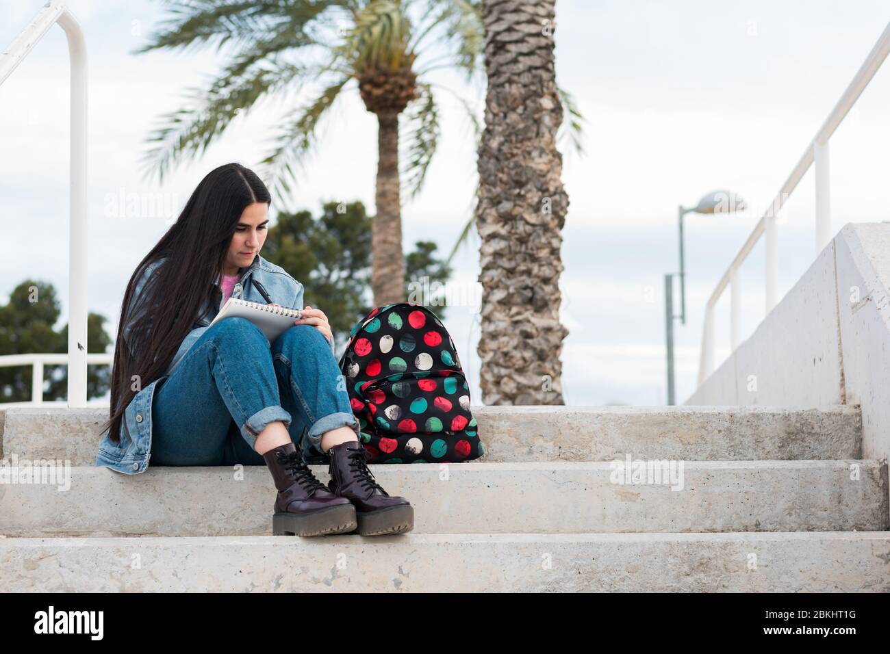 Young college student taking notes on campus outdoor Stock Photo - Alamy