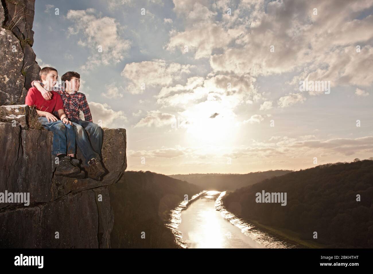 two friends sitting on a ledge Stock Photo - Alamy