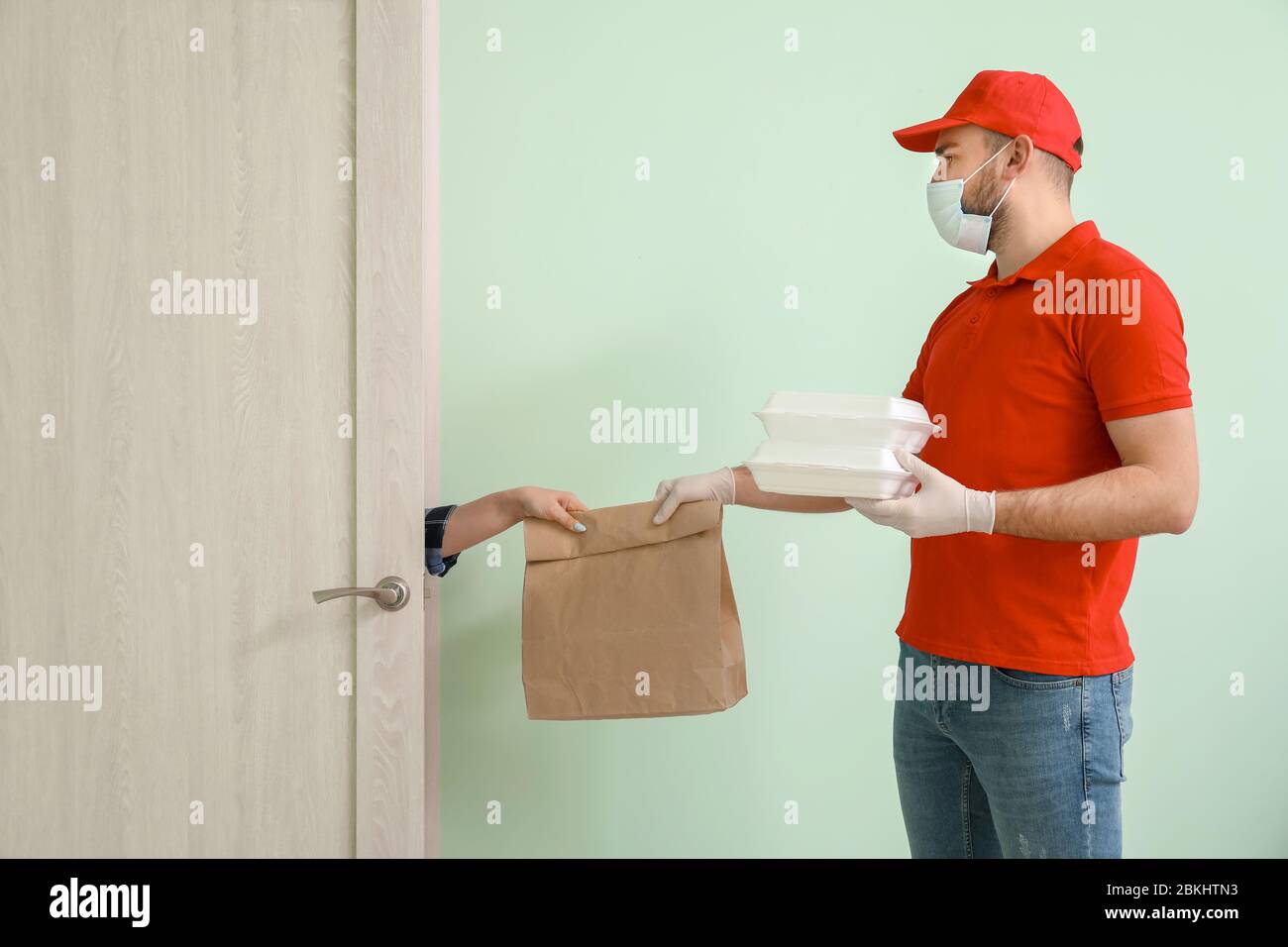 Customer taking order from courier of food delivery company Stock Photo ...