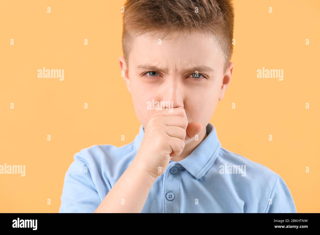 Ill coughing little boy on color background Stock Photo - Alamy