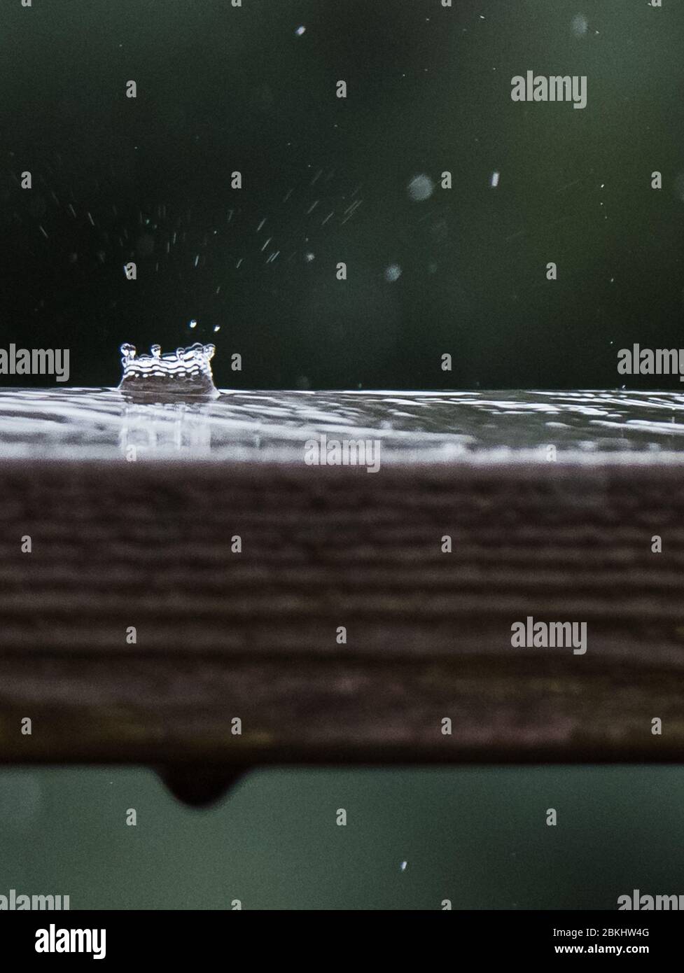 Close up of a raindrop hitting a wooden railing with a splash Stock ...