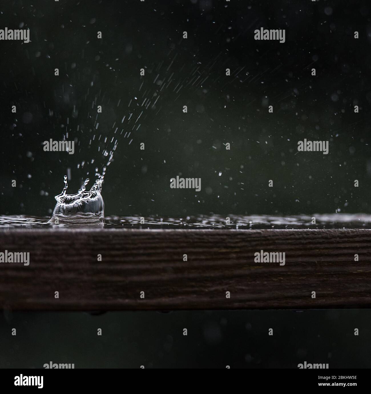 Close up of a raindrop hitting a wooden railing with a splash Stock ...