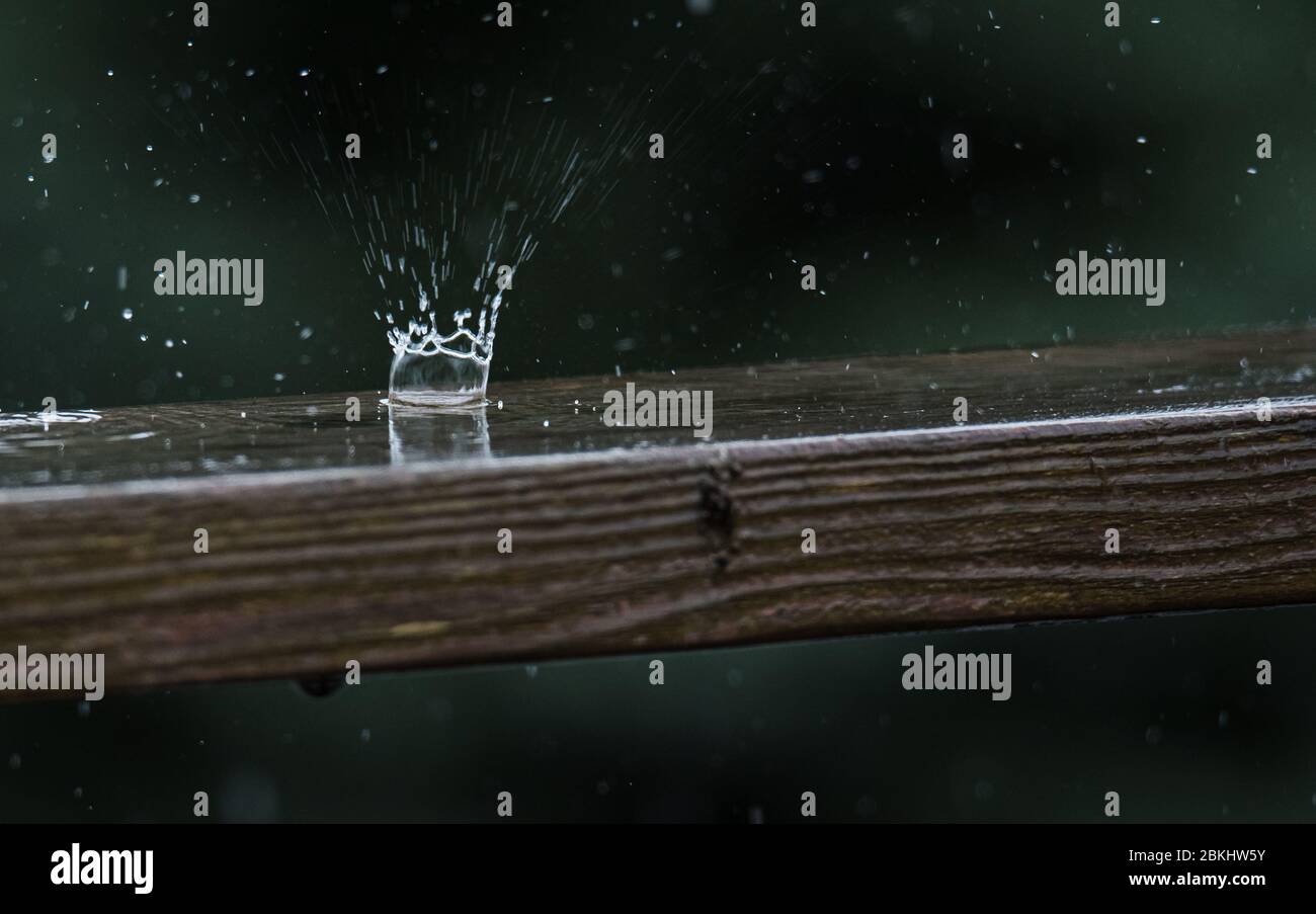 Close up of a raindrop hitting a wooden railing with a splash Stock ...