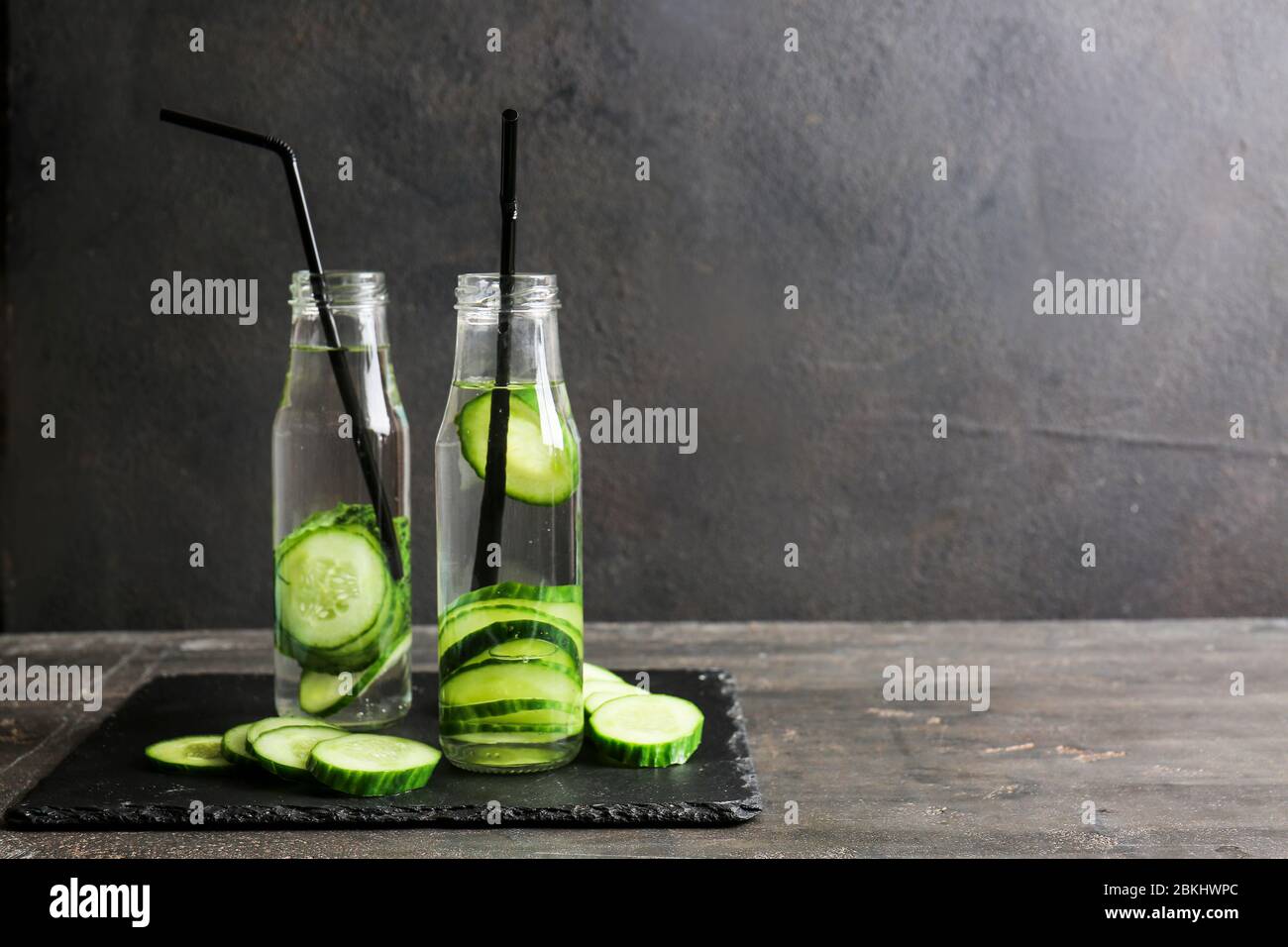 Bottles of infused cucumber water on dark background Stock Photo - Alamy