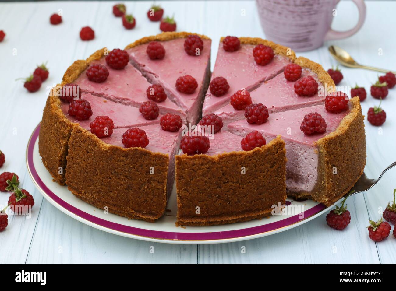 Homemade raspberry cheesecake cut in portions on a plate, located on ...