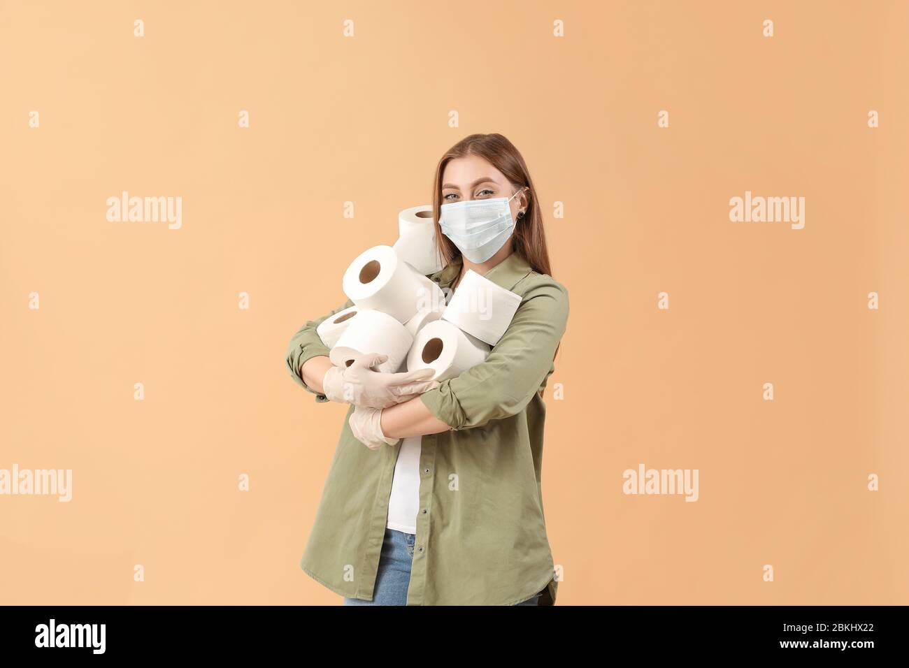 Woman in protective mask and with heap of toilet paper on color ...