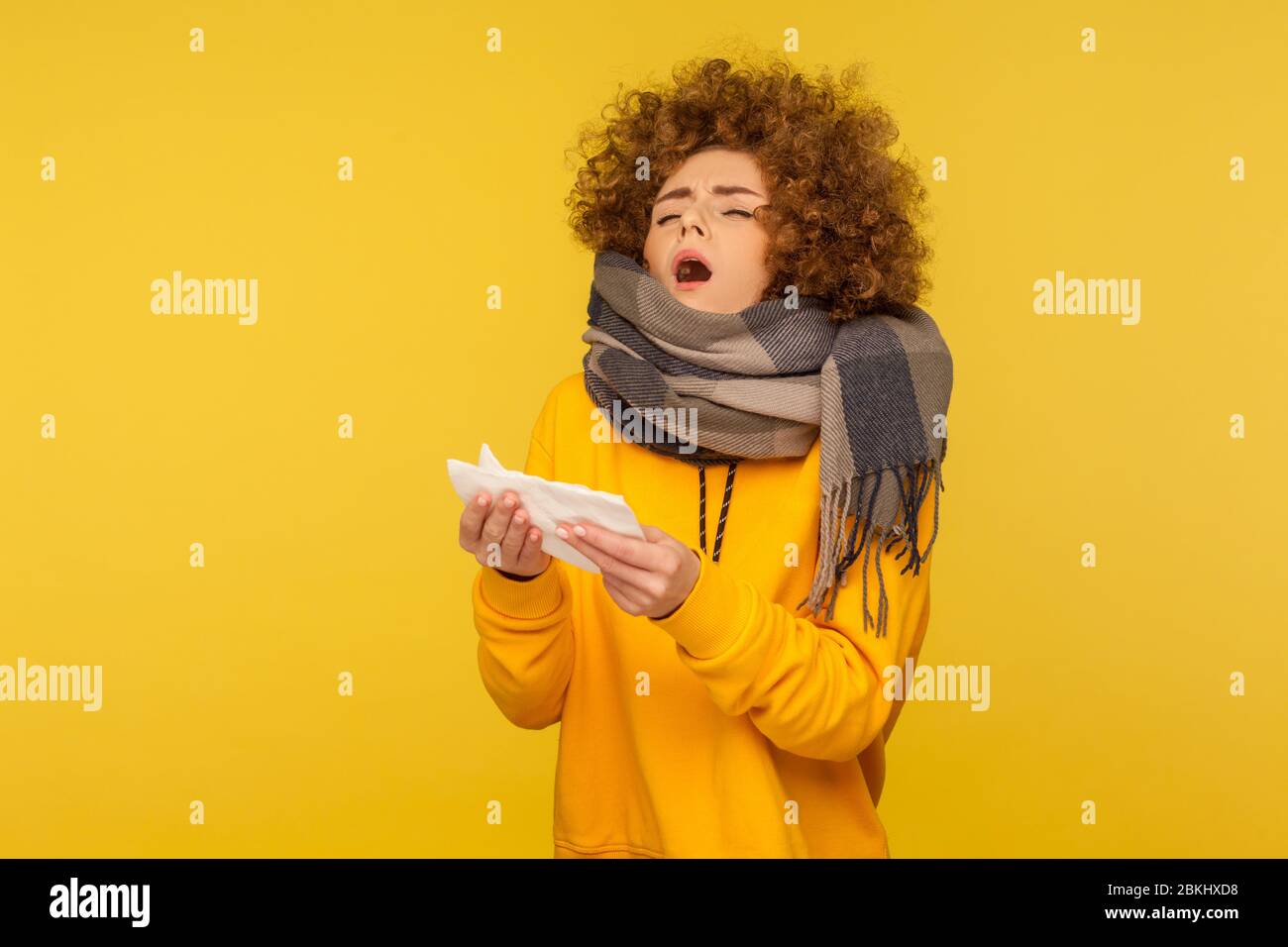 Seasonal influenza. Flu-sick woman with fluffy curly hair, wrapped in ...