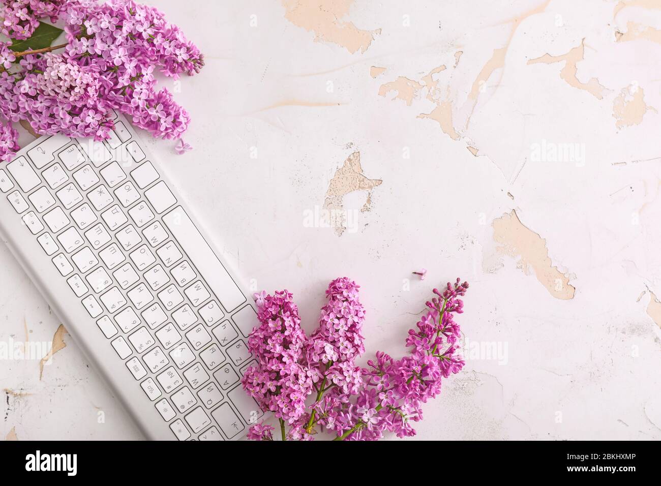 Beautiful lilac flowers and PC keyboard on table Stock Photo - Alamy