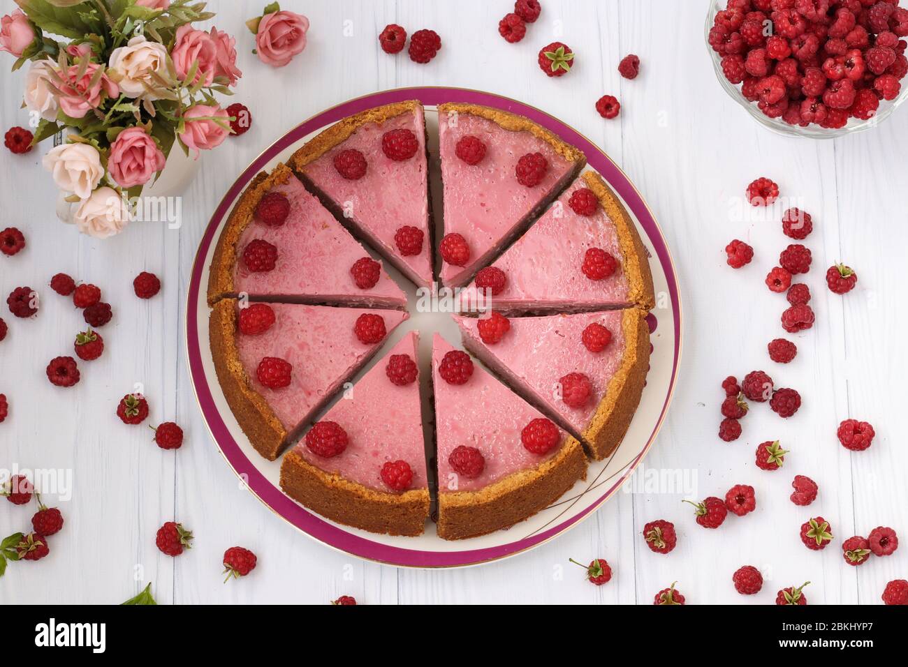 Homemade raspberry cheesecake cut in portions on a plate, located on ...