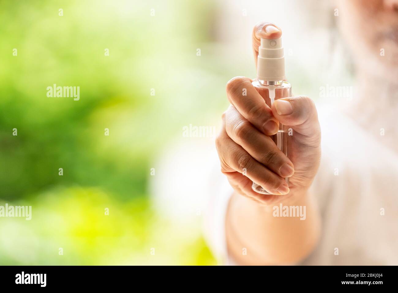 close-up Hand push on alocohol spray hand sanitizer bottle and spraying ...