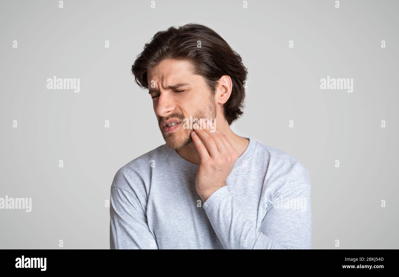 Man in pain. Beautiful man feeling toothache Stock Photo - Alamy