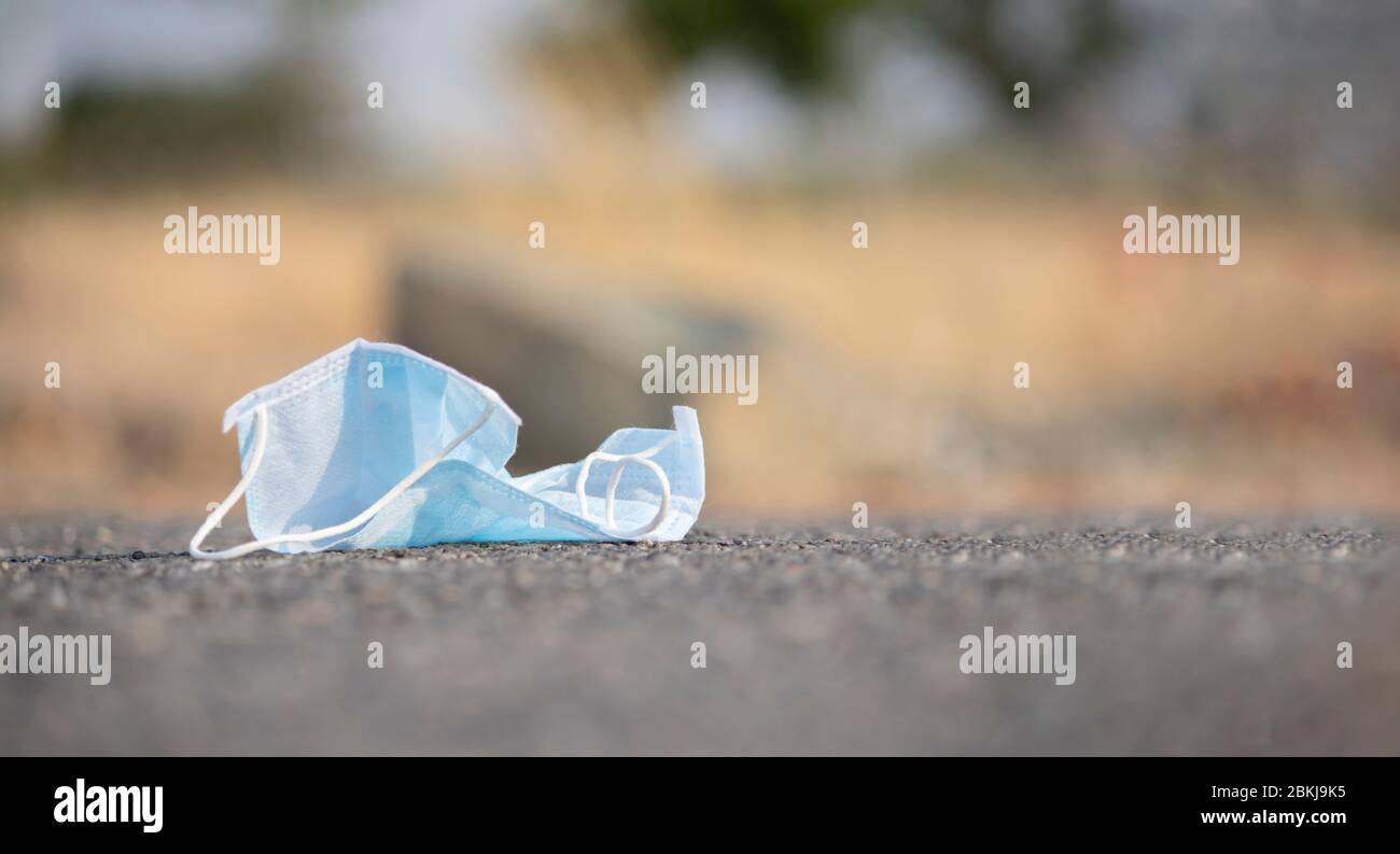 Discarded medical face mask stuck into road - concept of unhygienic ...