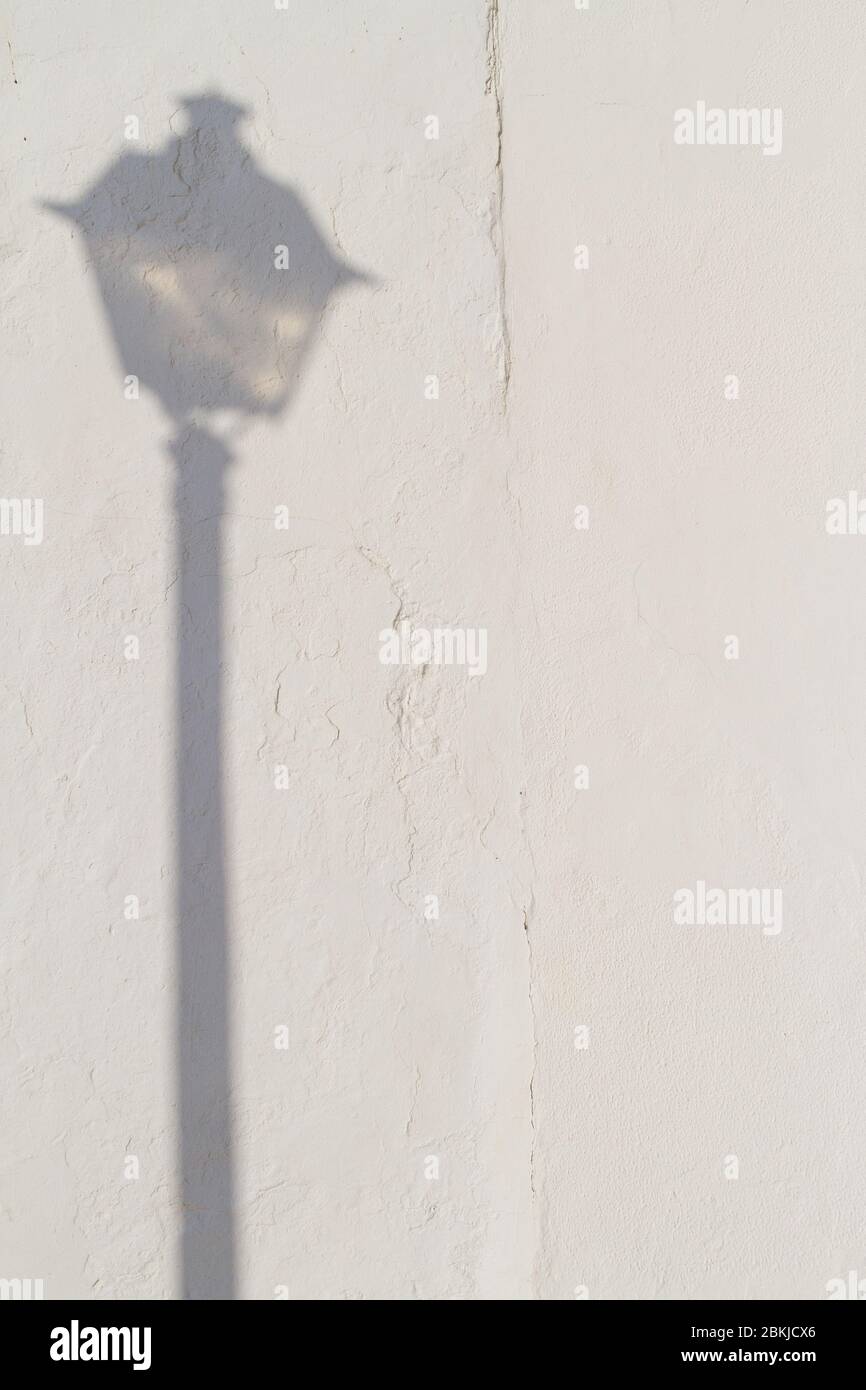 The shadow od a light post cast on a white stucco wall Stock Photo - Alamy