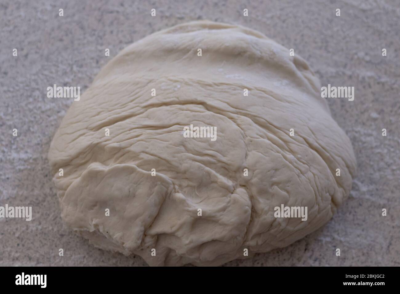 Homemade dough on a floured kitchen kitchen counter ready to be kneaded ...