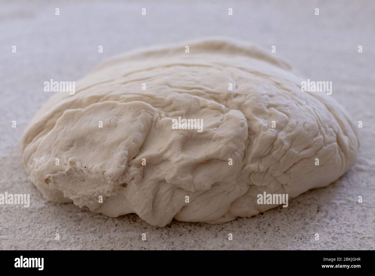 Homemade dough on a floured kitchen kitchen counter ready to be kneaded ...
