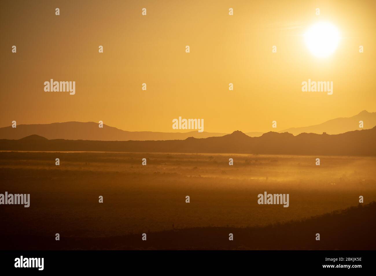 The sun rising over the mountains of the Arizona desert with natural ...