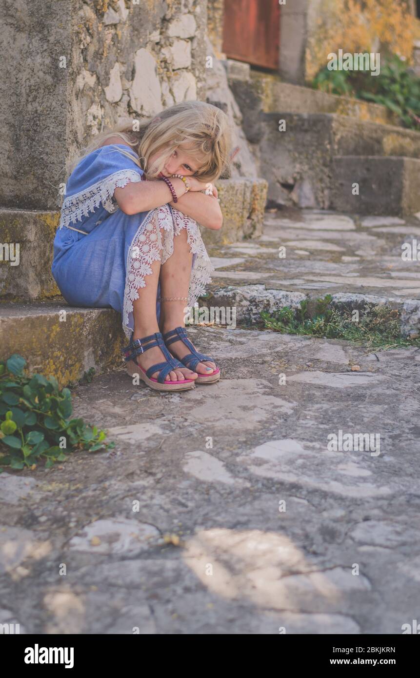 adorable little child sitting in historic stone stairs Stock Photo - Alamy