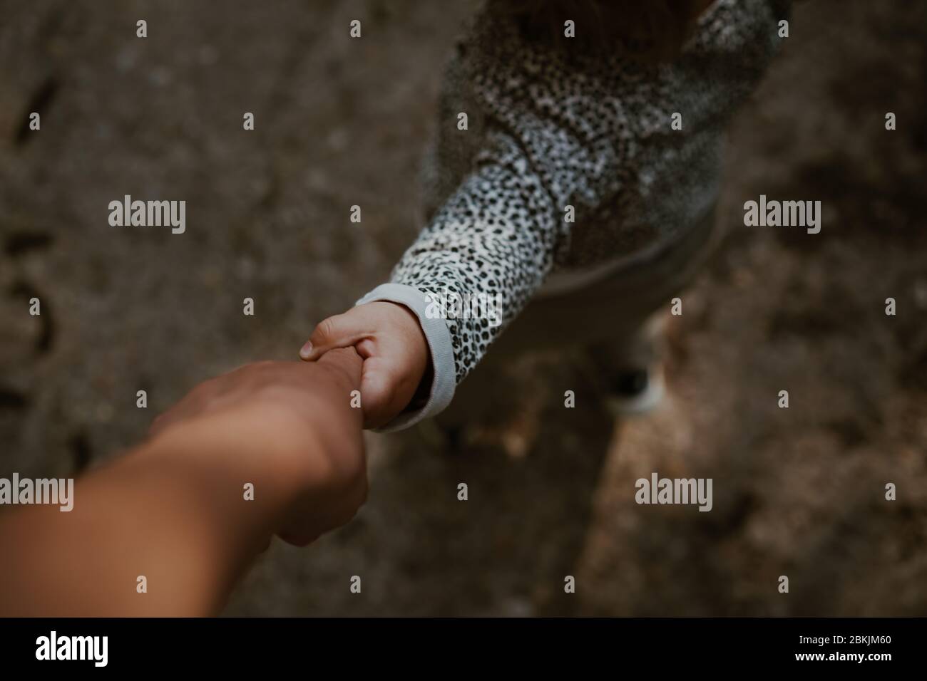 Little boy holding mums hand Stock Photo - Alamy