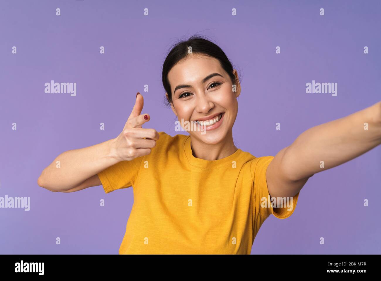 Cheerful young pretty sportswoman standing isolated over violet ...