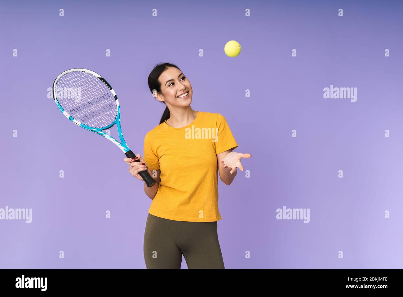 Cheerful young pretty sportswoman standing isolated over violet ...