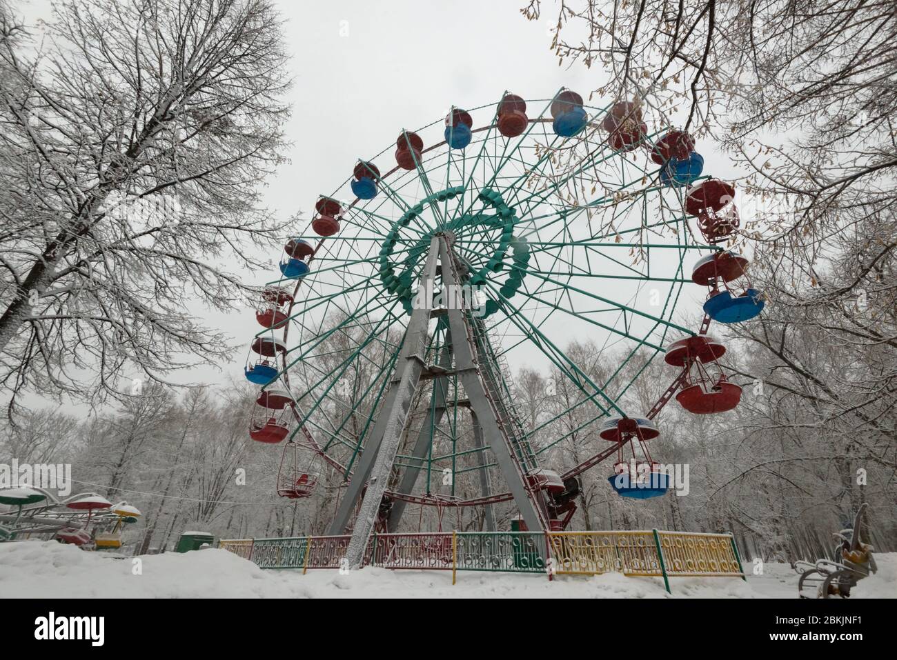 The Ferris wheel in the park in winter is covered with snow, a ...