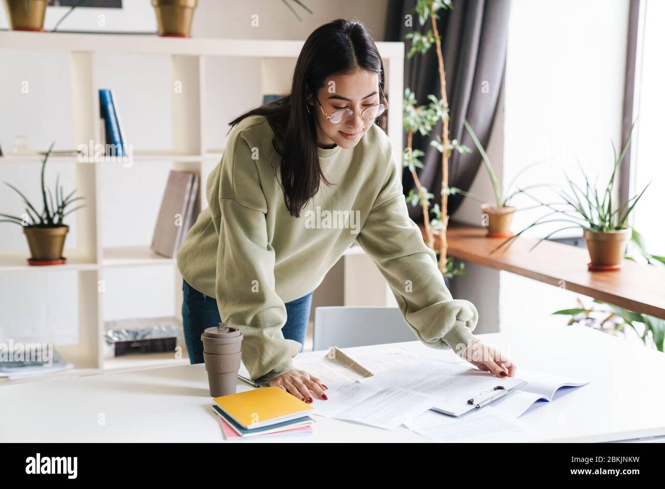 Image of a beautiful happy optimistic young girl student indoors ...