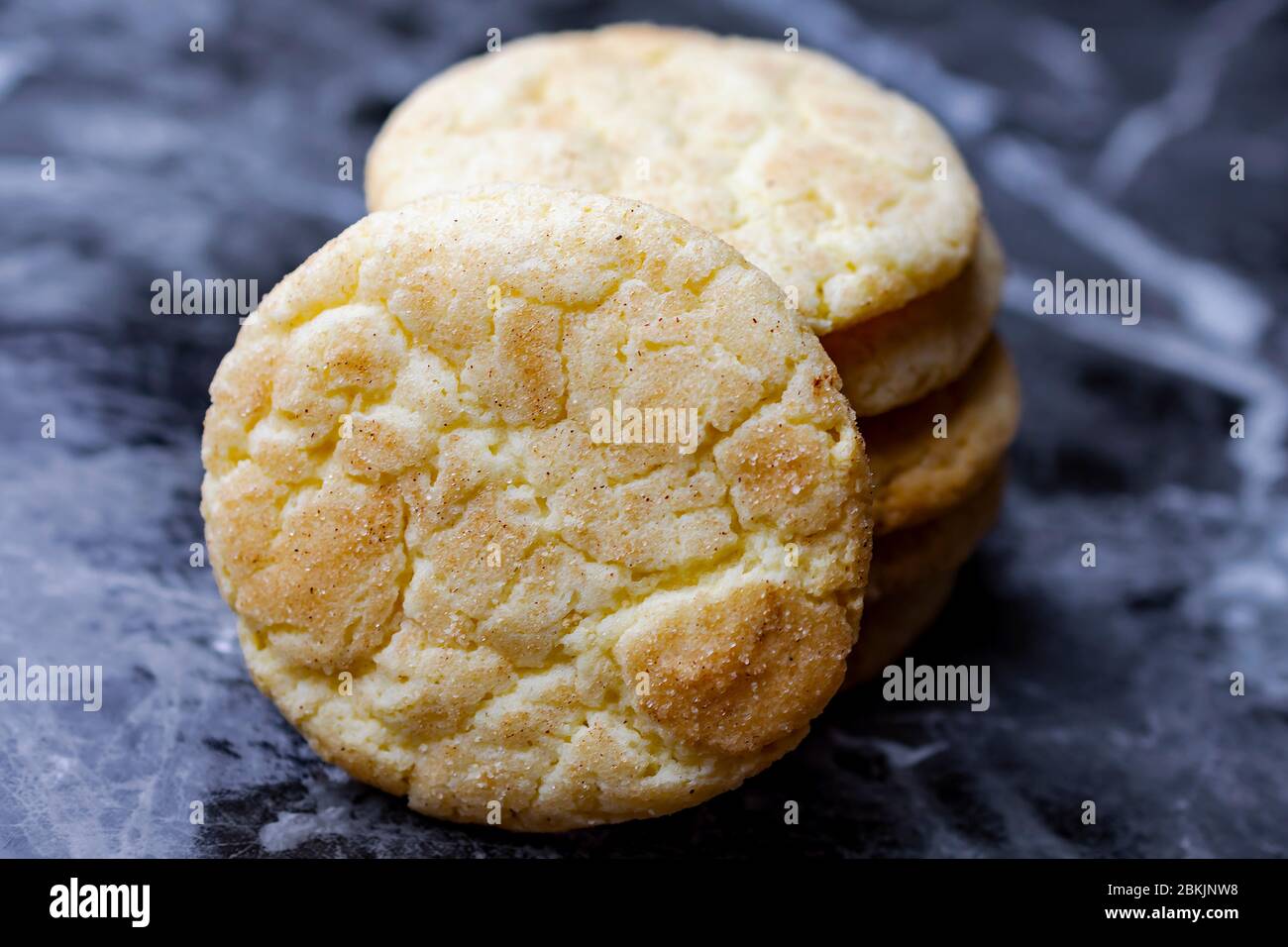 A stack of snickerdoodle cookies on a dark white and black marble ...
