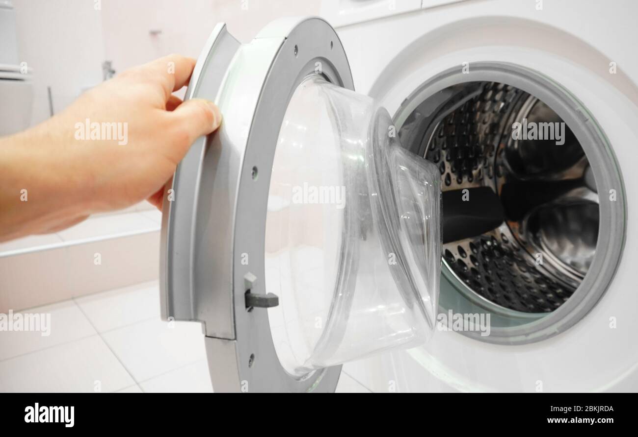 Male hand open the door in washing machine Stock Photo - Alamy