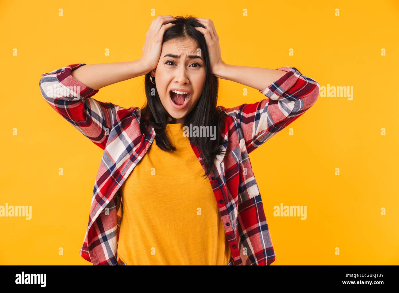 Image of nervous young woman grabbing her head and screaming isolated ...