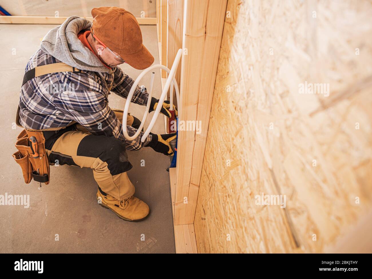 Male Plumber Installing Water Line In New Housing Stock Photo - Alamy