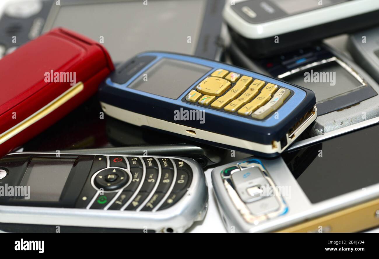 pile of used old mobile damaged phones technology background Stock ...
