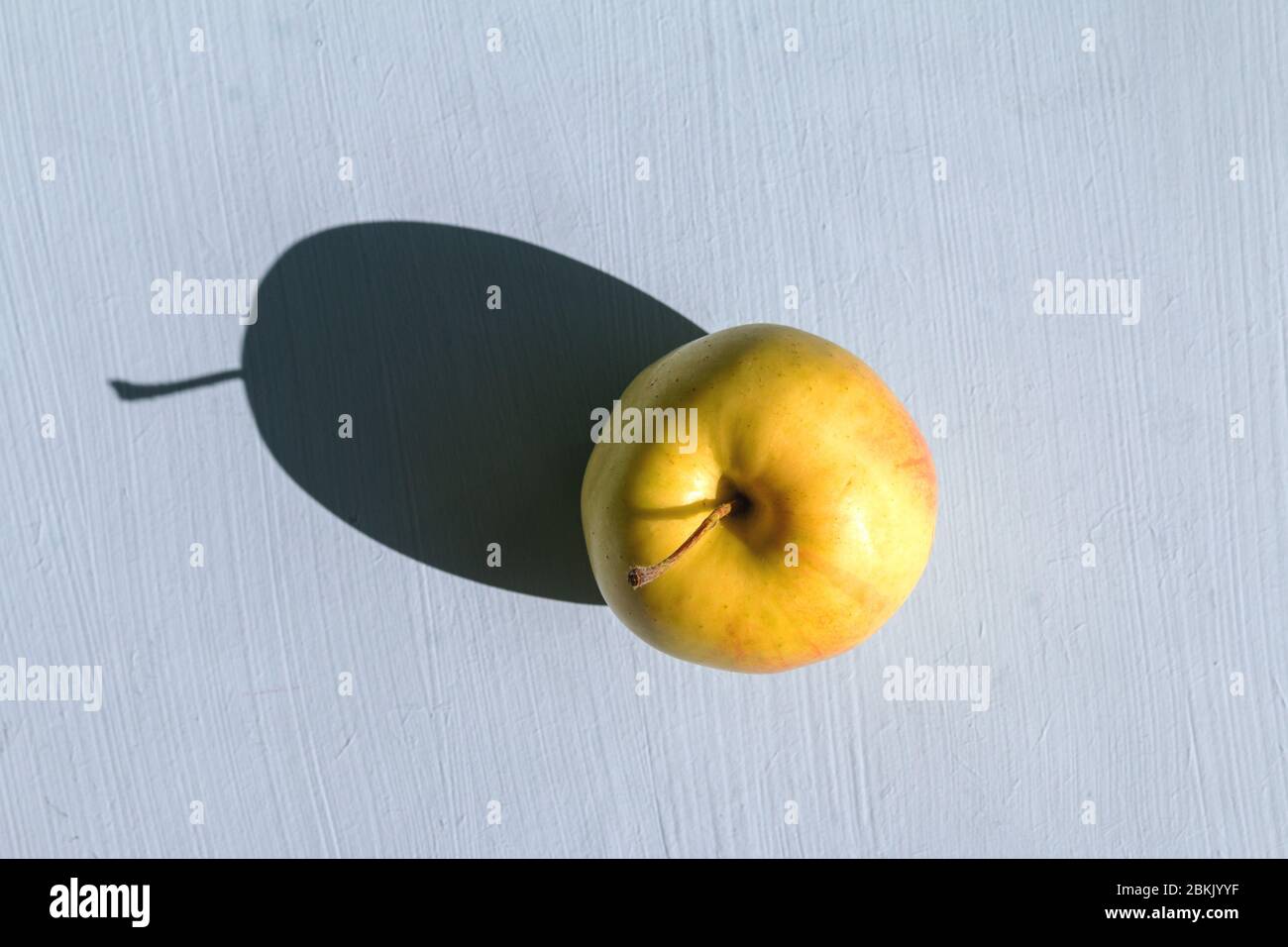 view from above yellow apple with a hard sunlight and deep shadow on a ...