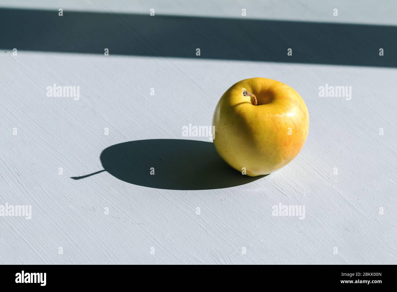 view from above yellow apple with a hard sunlight and deep shadow on a ...