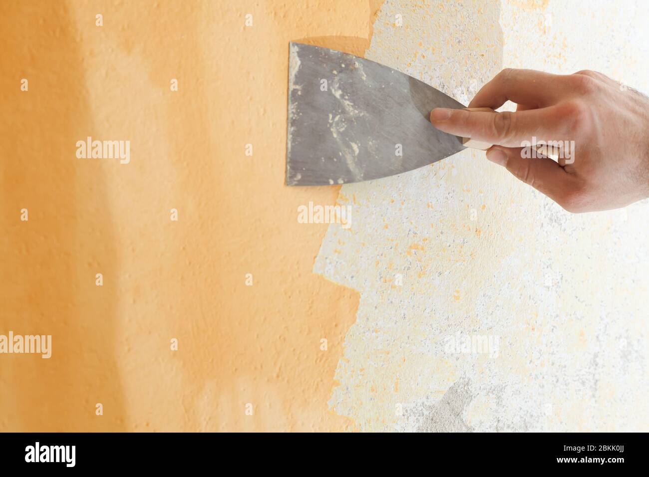 Scraping old plaster and applying new. Reconstruction of a new house ...