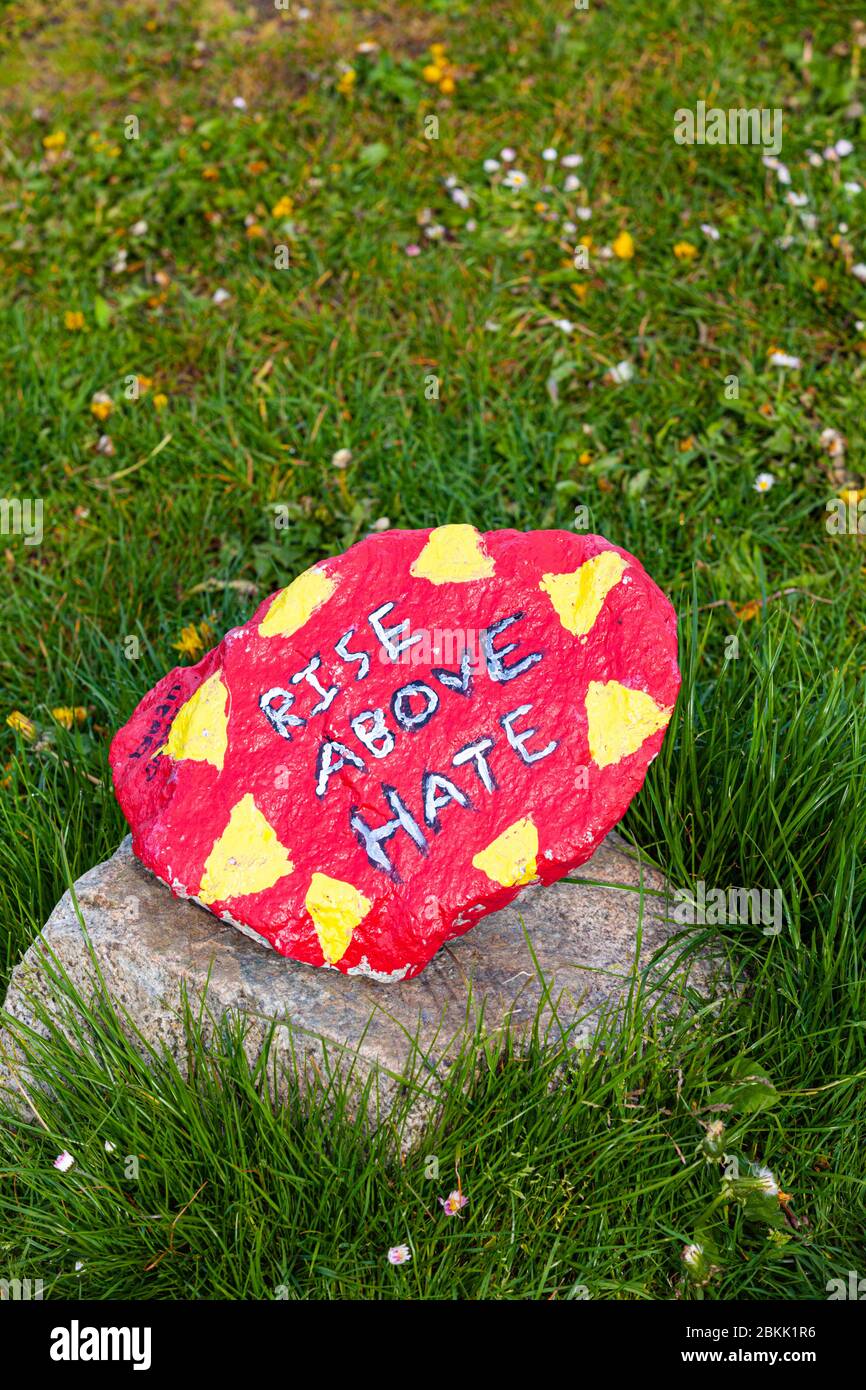 Rise Above Hate message painted on a rock and placed in a park setting ...