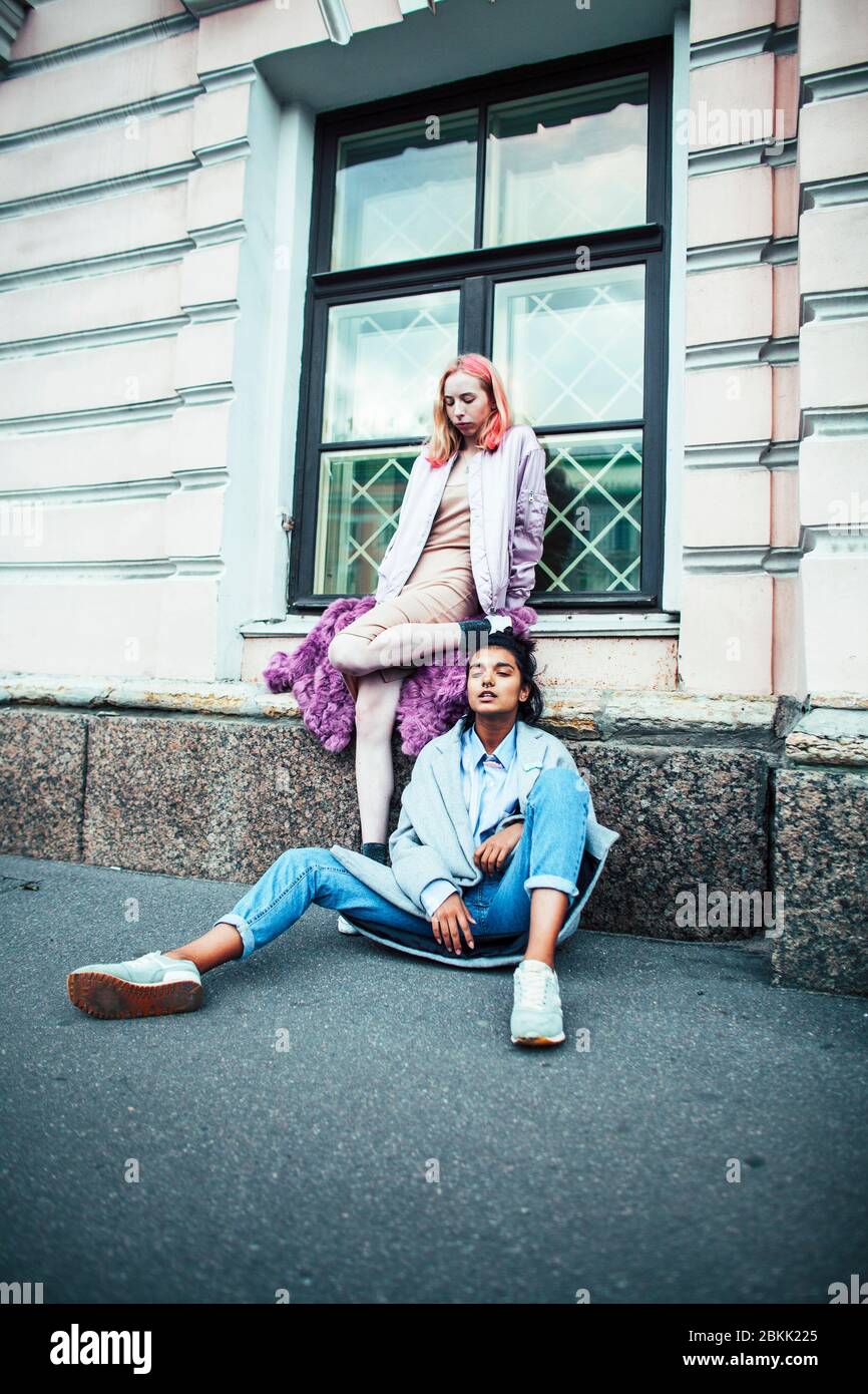 Two teenage girls infront of university building smiling, having fun ...