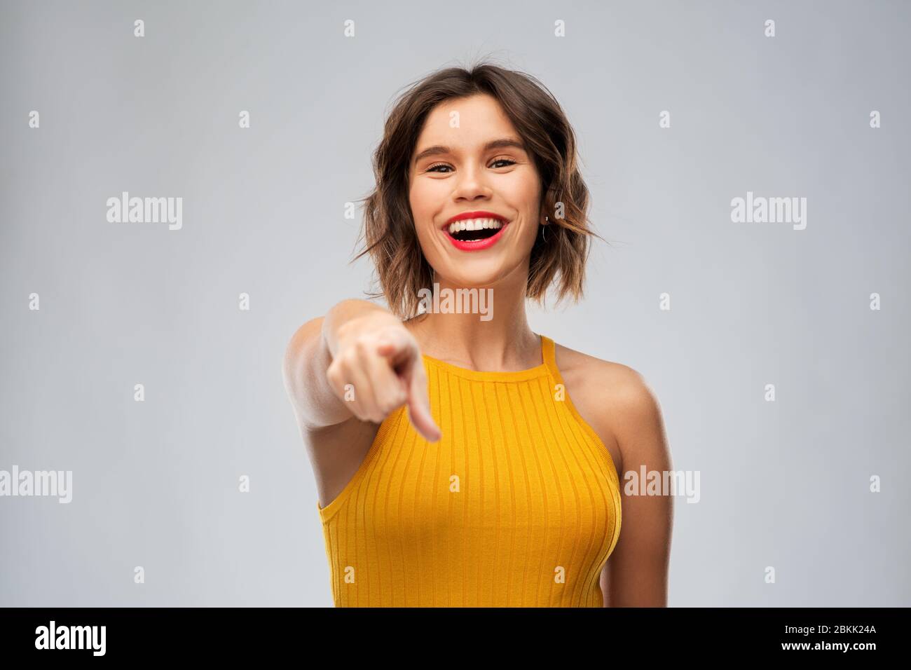 happy smiling young woman pointing to camera Stock Photo - Alamy
