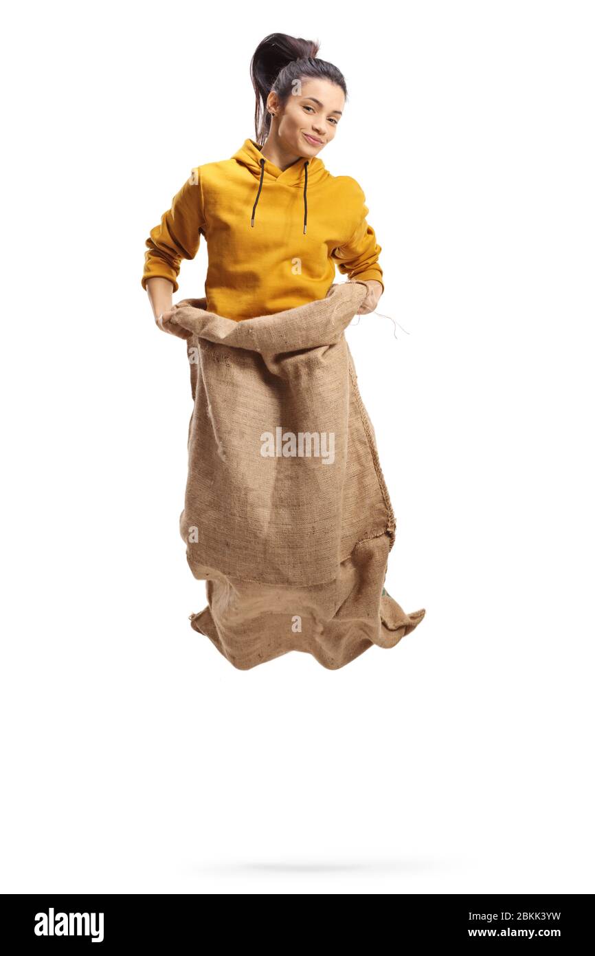 Smiling young female jumping in a sack isolated on white background ...