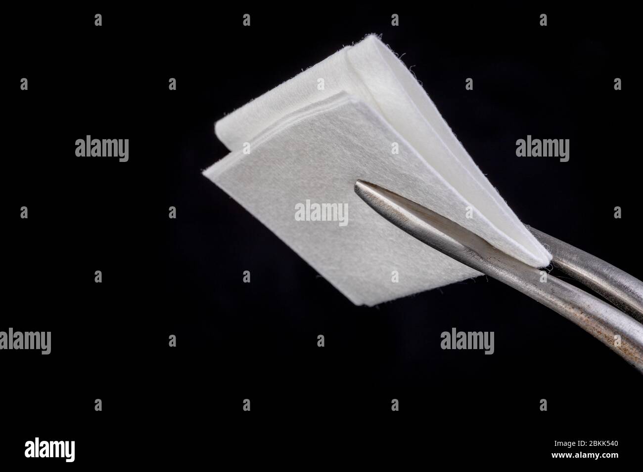 White swab clamped in metal surgical forceps. Accessories for doctors ...