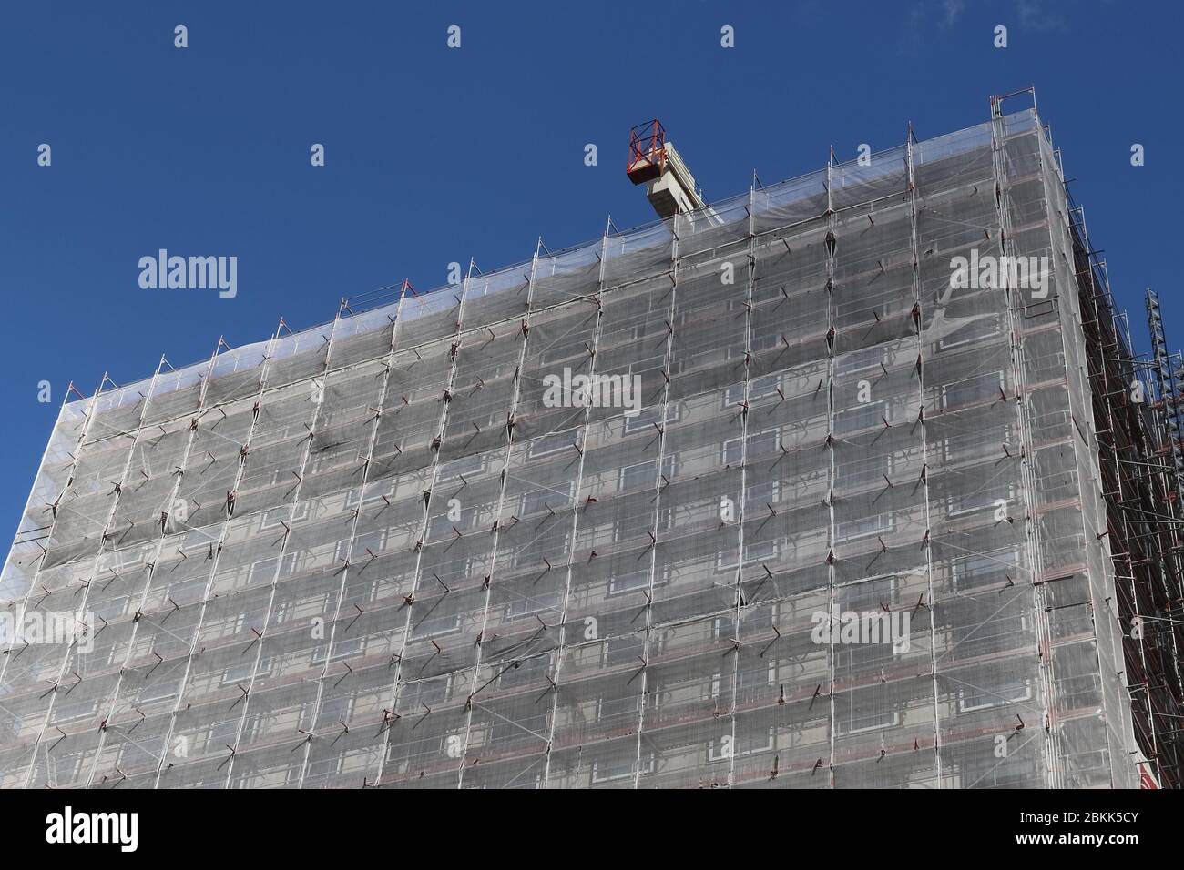 Scaffolding providing platforms for work in progress on a new apartment ...
