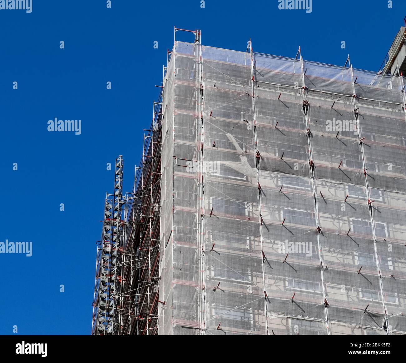 Scaffolding providing platforms for work in progress on a new apartment ...