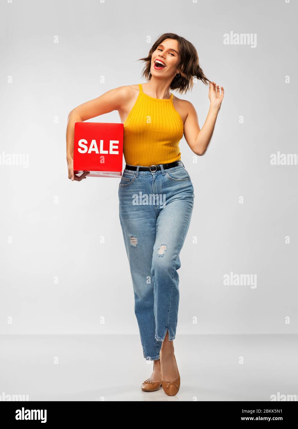 happy smiling young woman posing with sale sign Stock Photo - Alamy