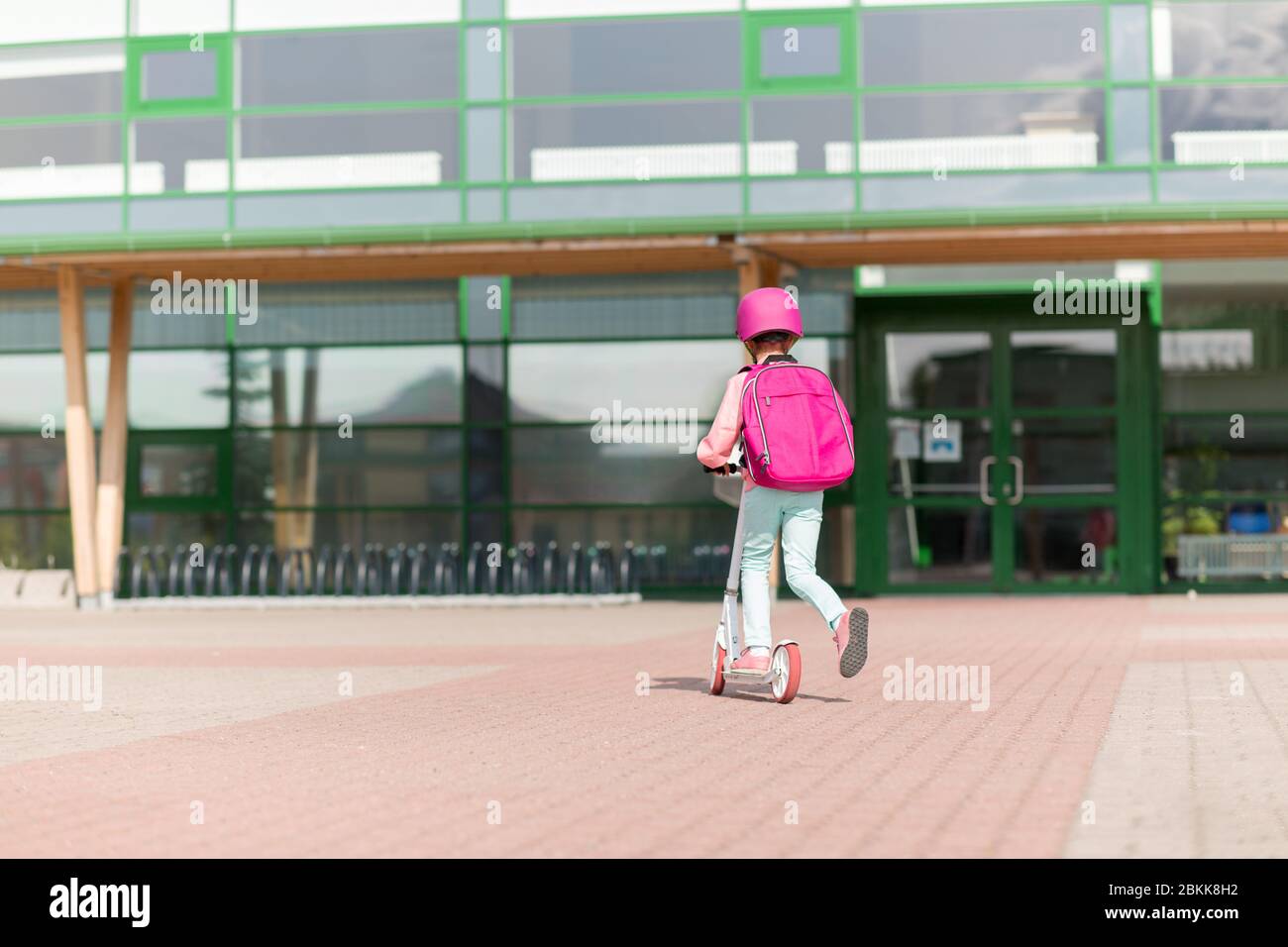 school girl with backpack riding scooter Stock Photo - Alamy