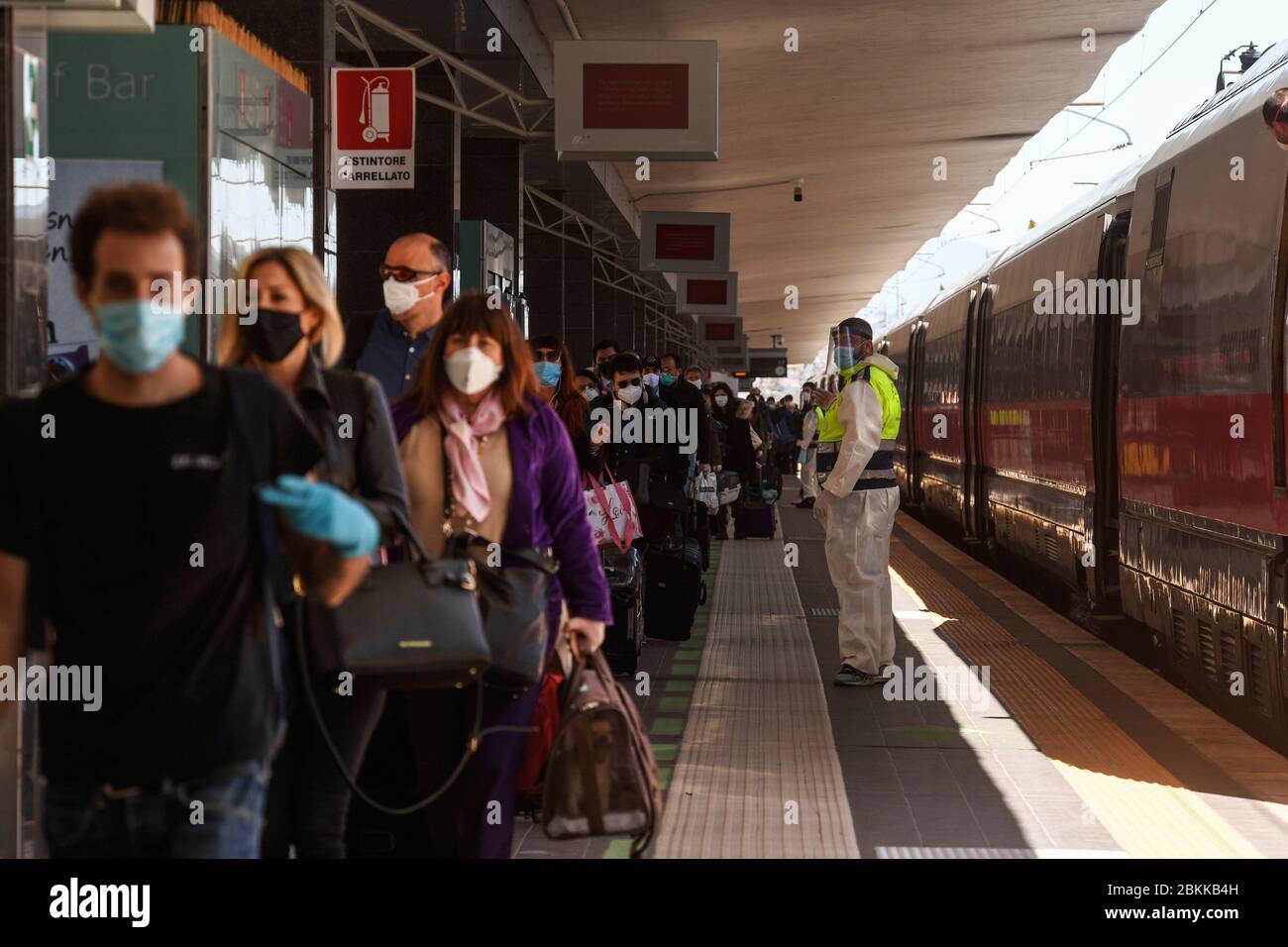 Passengers wearing protective masks line up after arriving with a ...