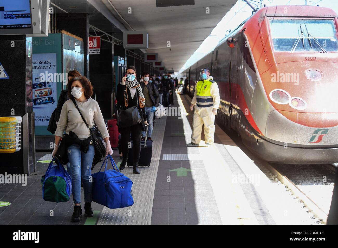 Passengers wearing protective masks line up after arriving with a ...
