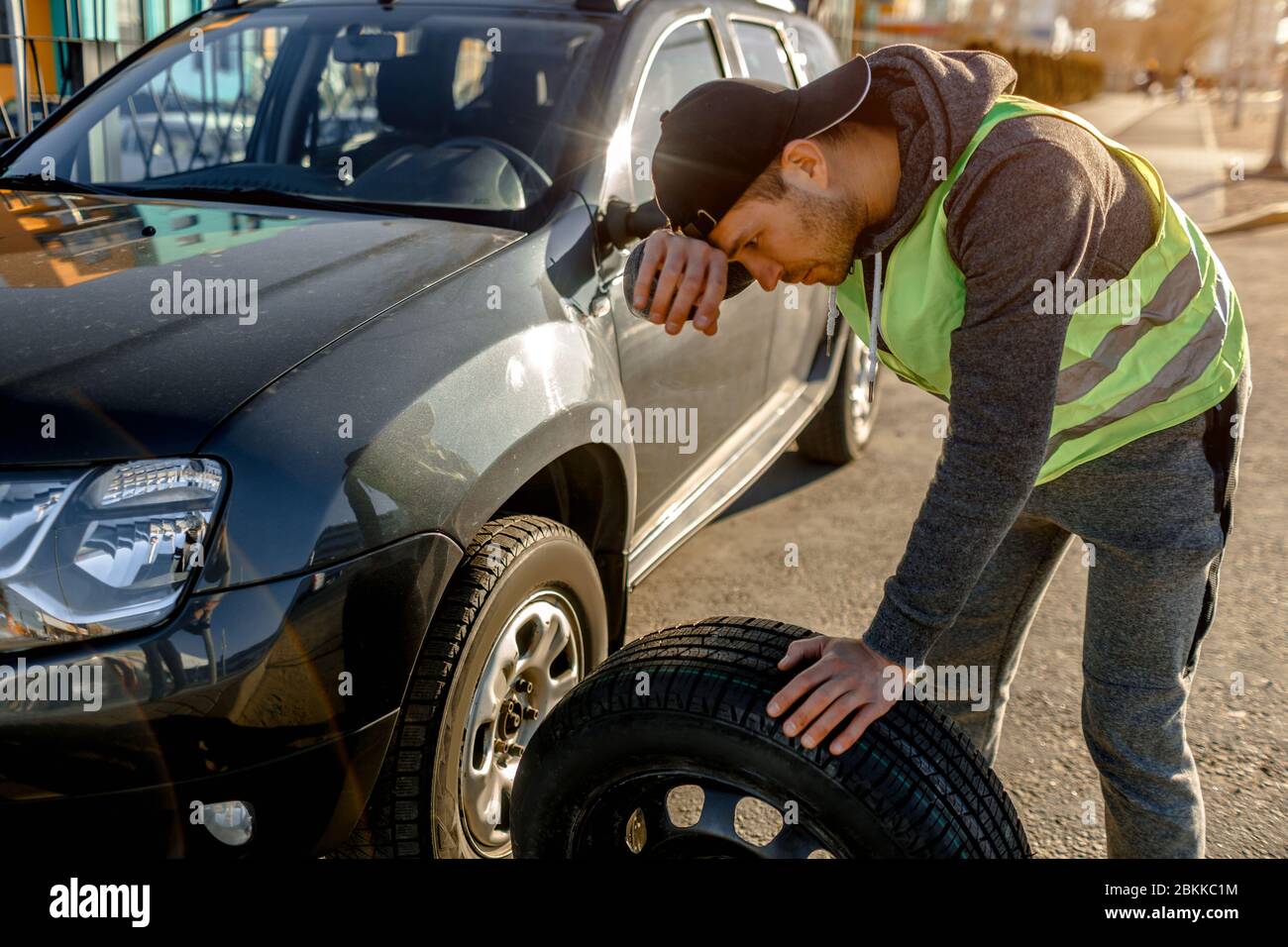Transportation, traveling concept. Worker changes a broken wheel of a ...